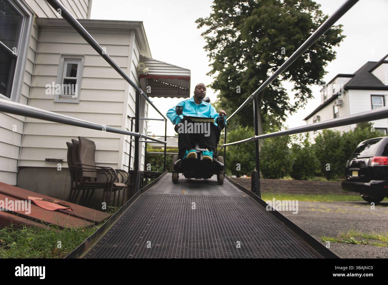 African American man with disability sitting in motorized wheelchair ...