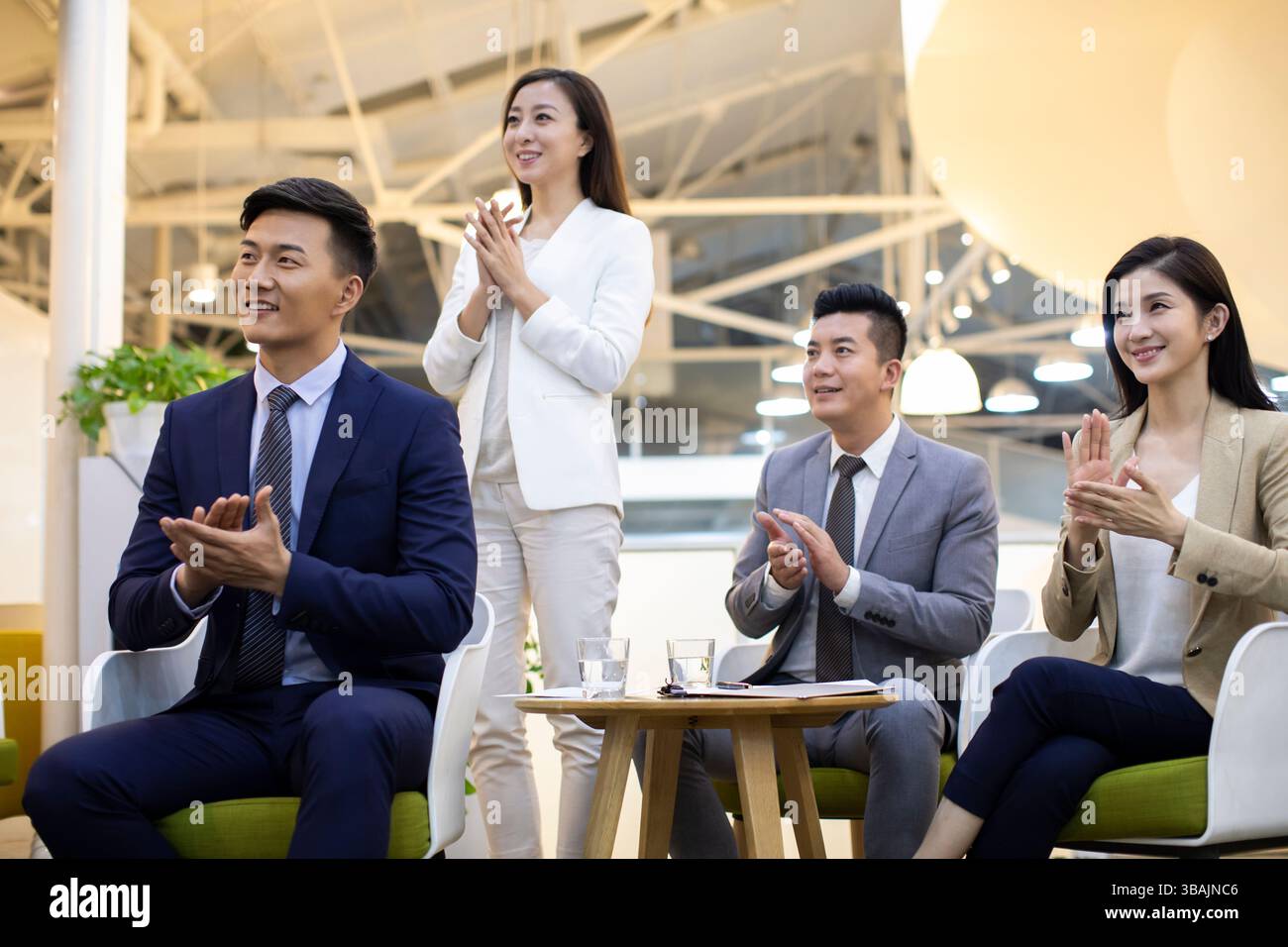 Chinese business people clapping hands during meeting in office Stock ...