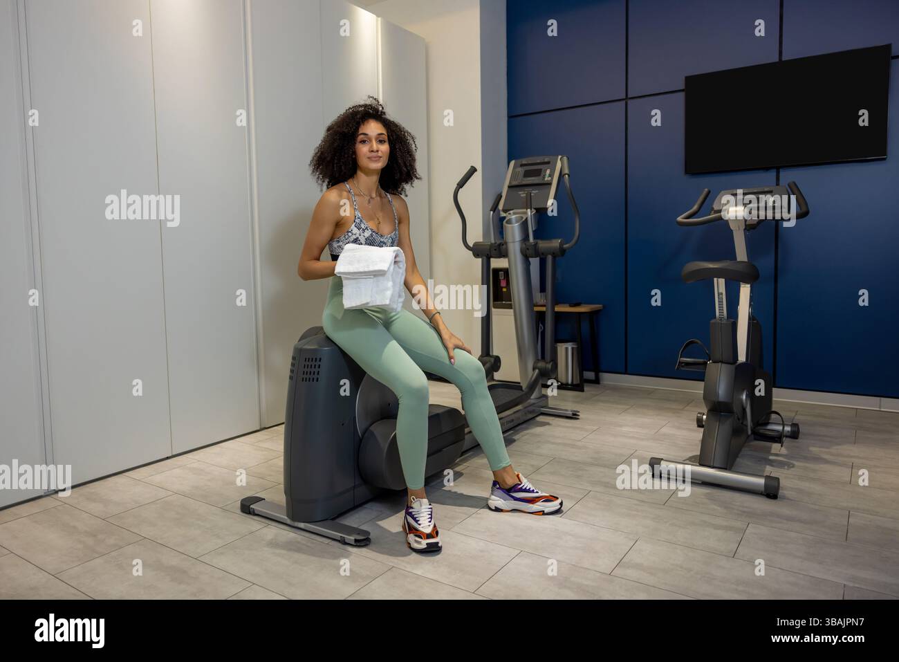 After workout. Young woman wiping sweat after the workout in gym Stock ...