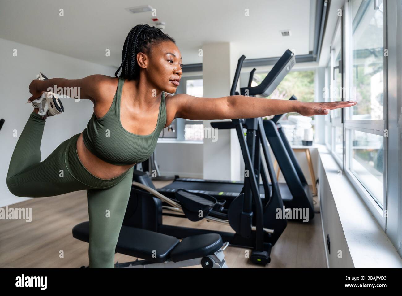 Manager stretching legs in hotel fitness room during business trip ...