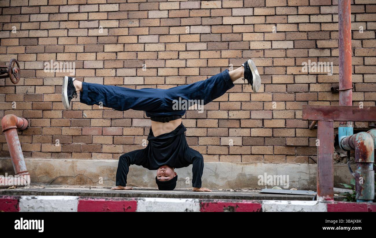 A cool, energetic Asian male b-boy hiphop breakdancer is showcasing his ...
