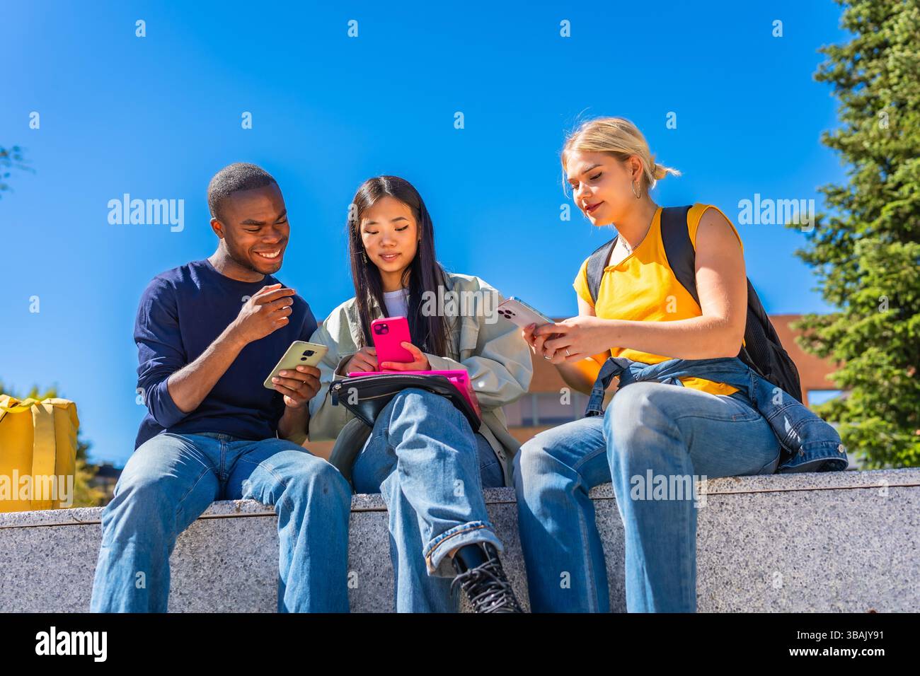 Low angle view photo of a group of students using smartphones sitting ...