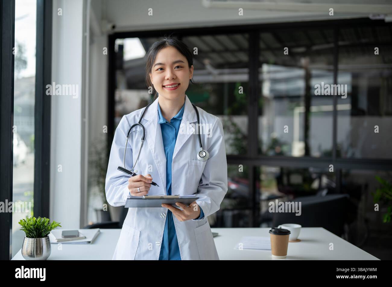 An attractive young Asian female doctor is checking medical cases on a ...