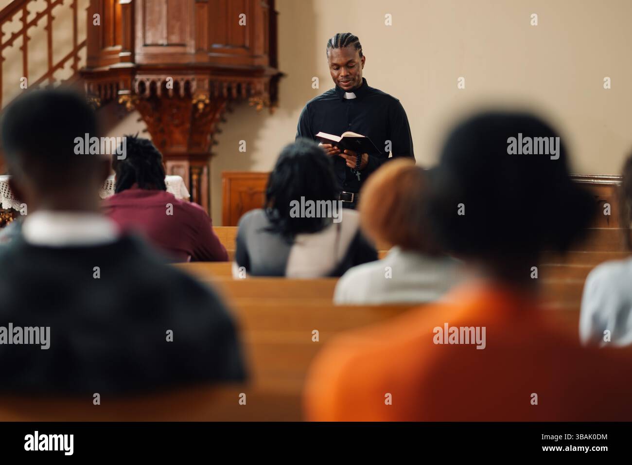 Priest reading from the bible at the altar during a service, surrounded ...