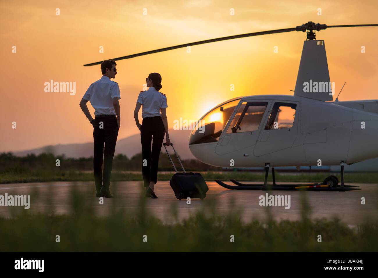 Chinese helicopter pilots walking with luggage Stock Photo - Alamy