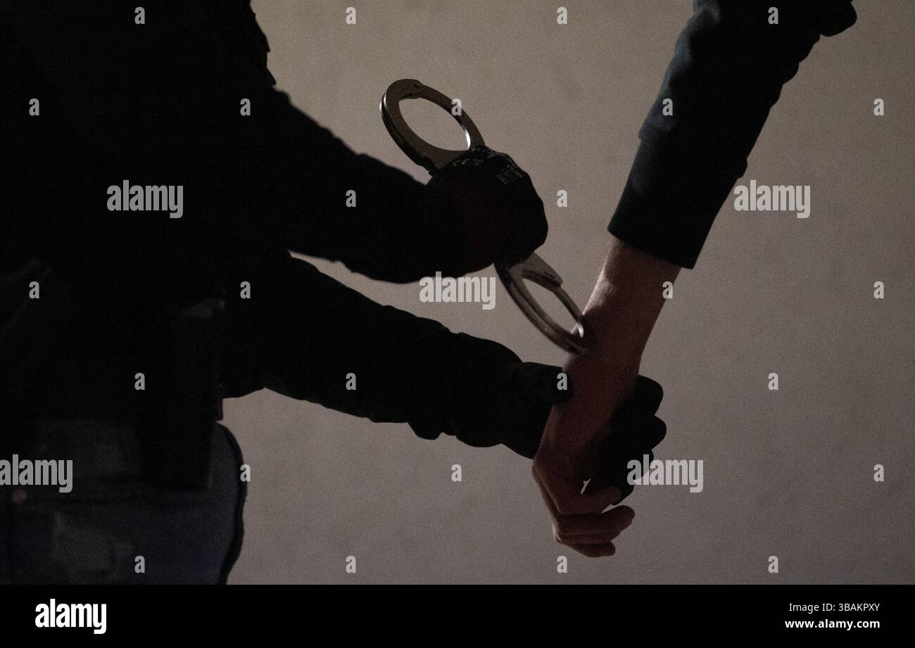 Munich, Germany. 12th May, 2025. A customs investigator handcuffs a man ...