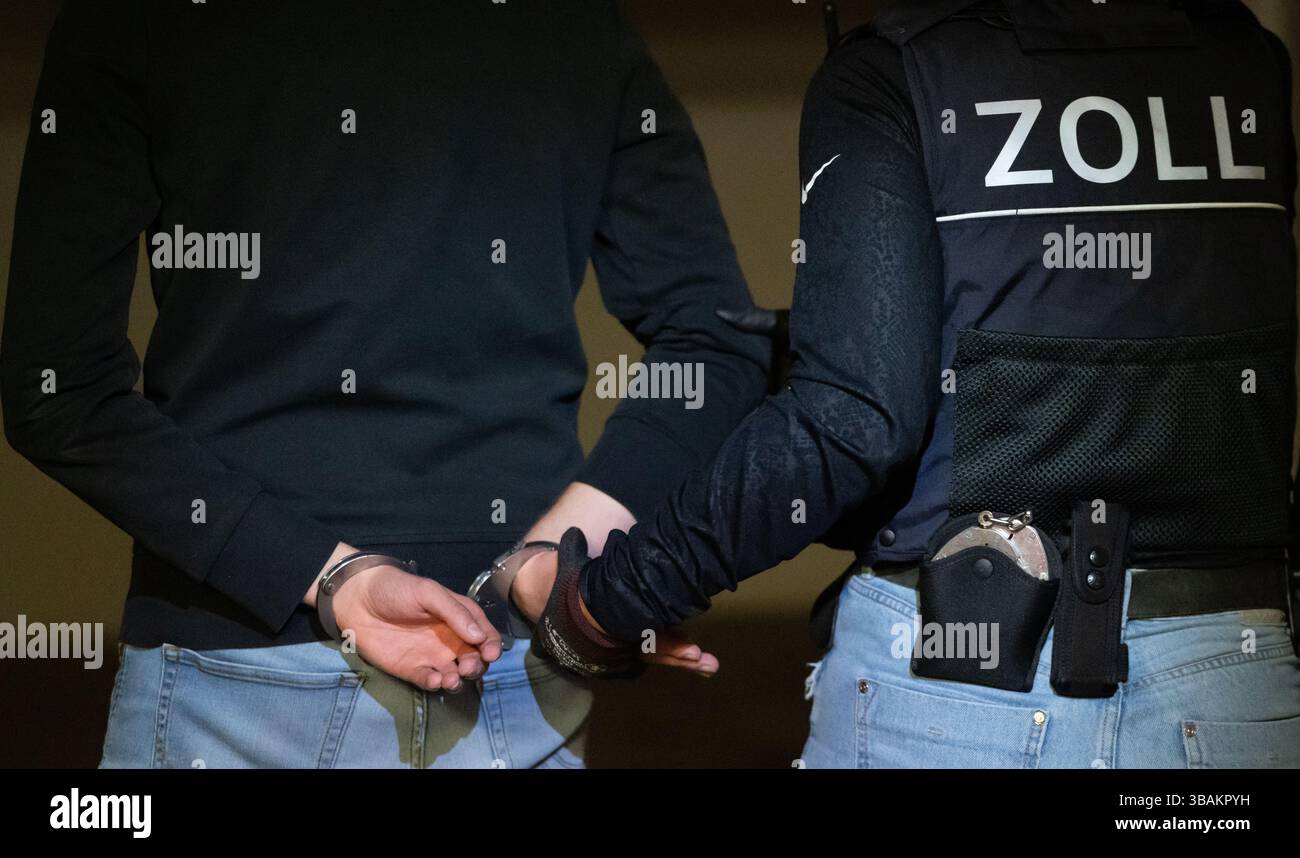 Munich, Germany. 12th May, 2025. A customs investigator holds a man in ...