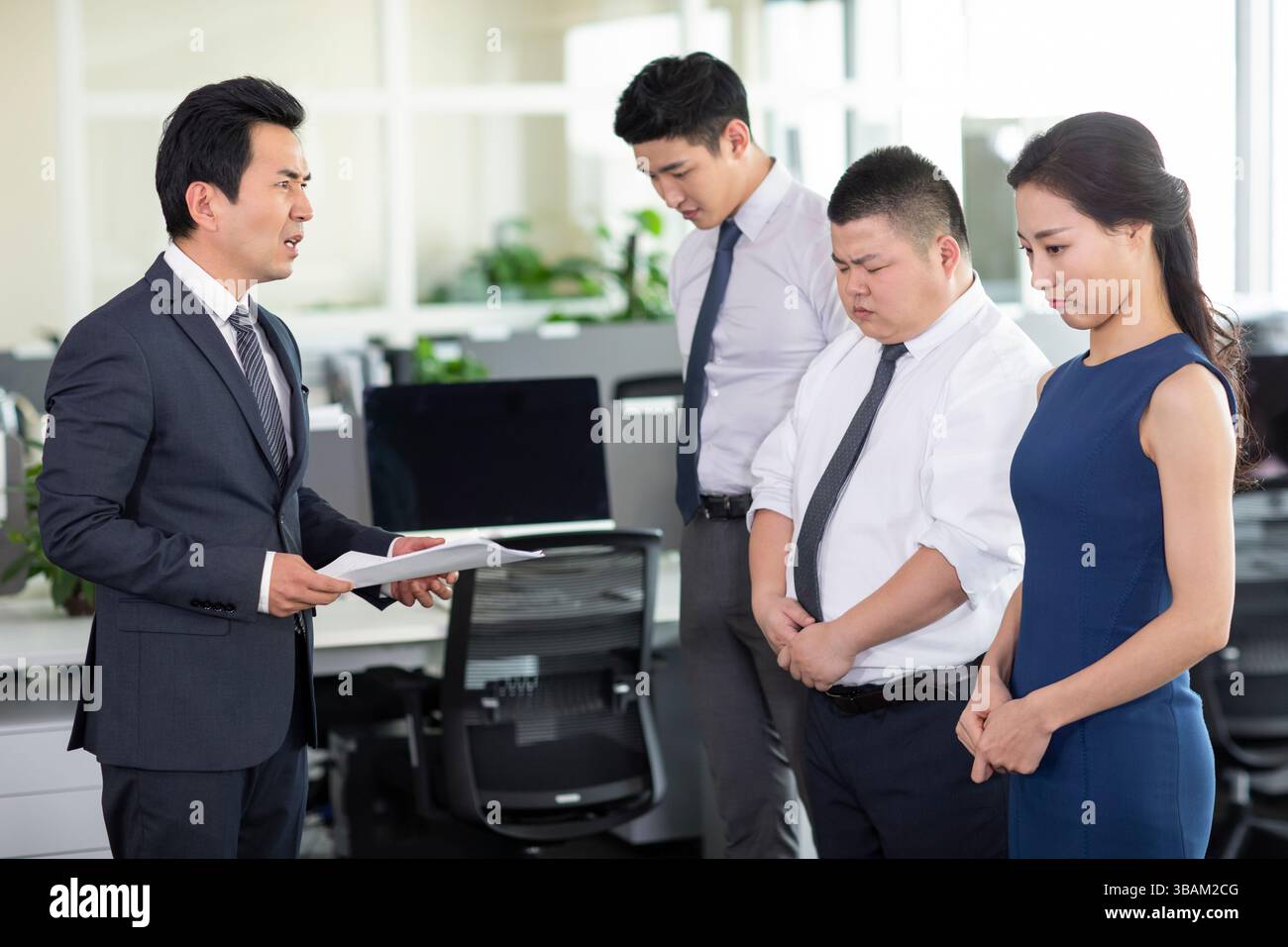 Chinese male boss standing and scolding his employees in office Stock ...