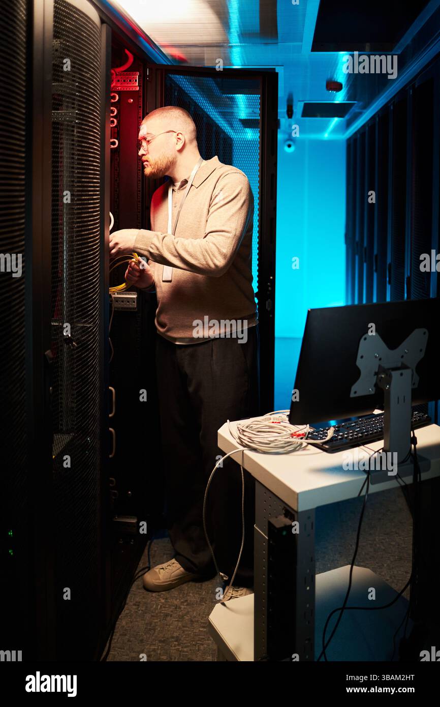 Person working in a data center managing servers and equipment Among ...