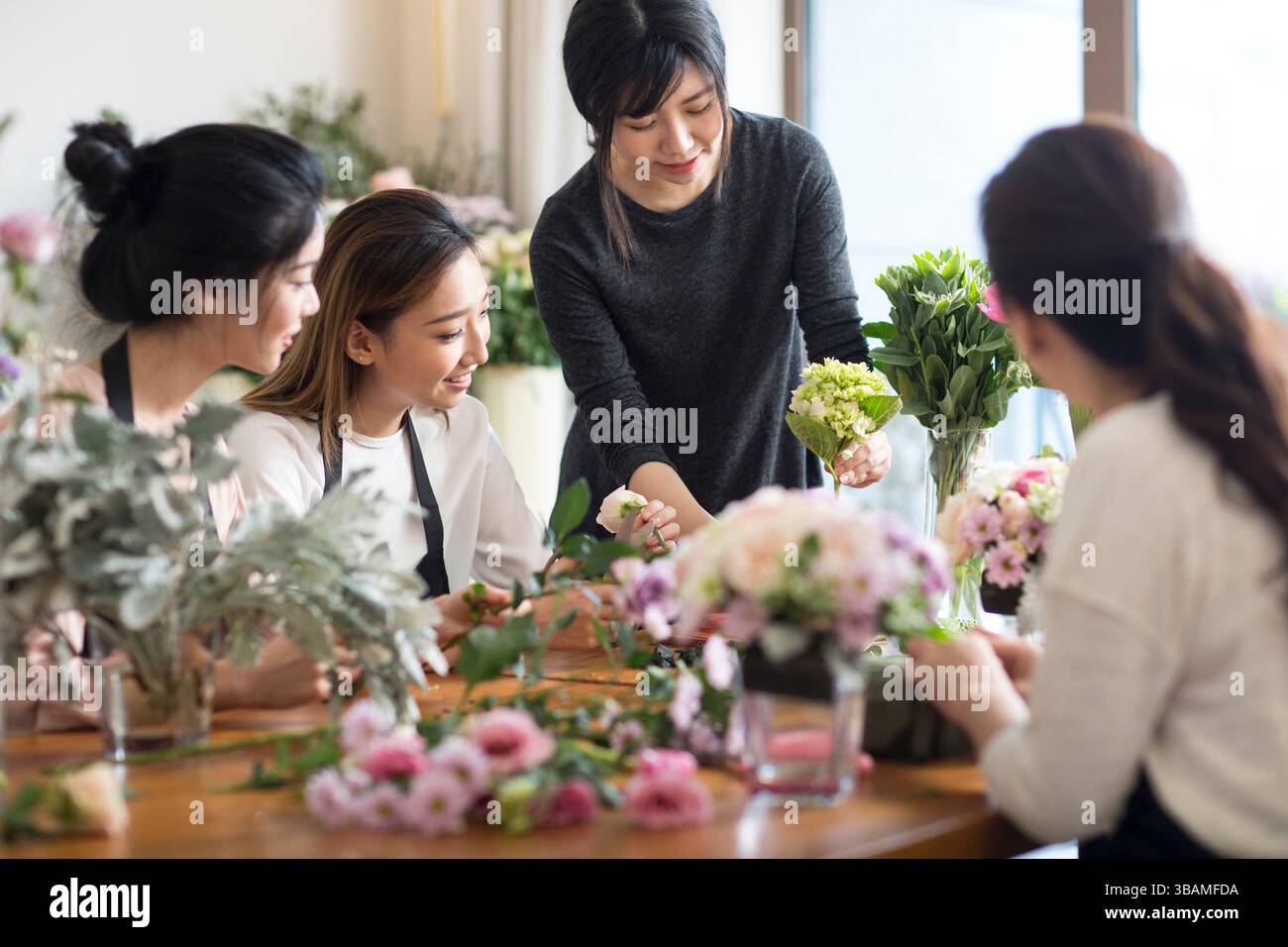 Chinese female teacher teaching women how to arrange flowers in ...
