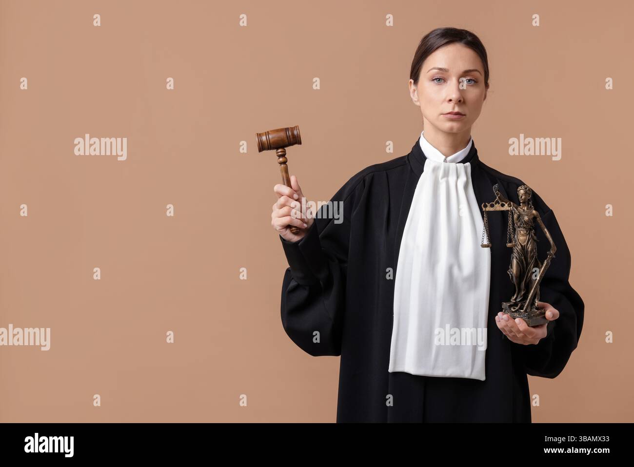 Judge with mallet and figure of Lady Justice on light brown background ...