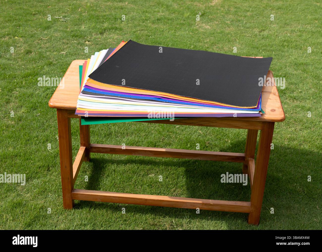 Colorful craft chart papers spread on wooden table. Art and photography ...
