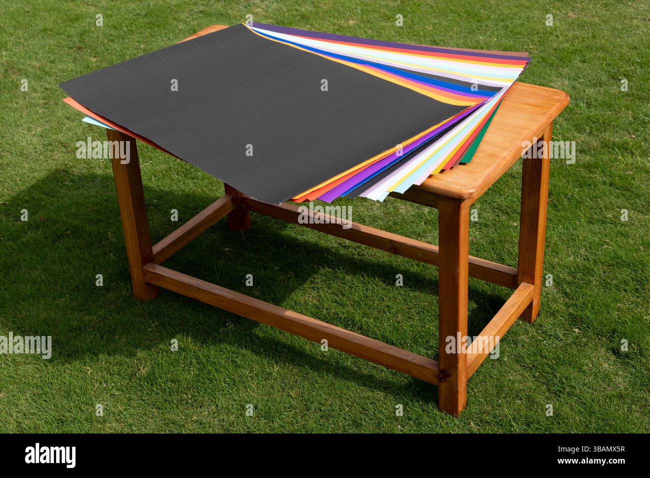 Organized stack of colored chart sheets on wooden table for DIY and ...