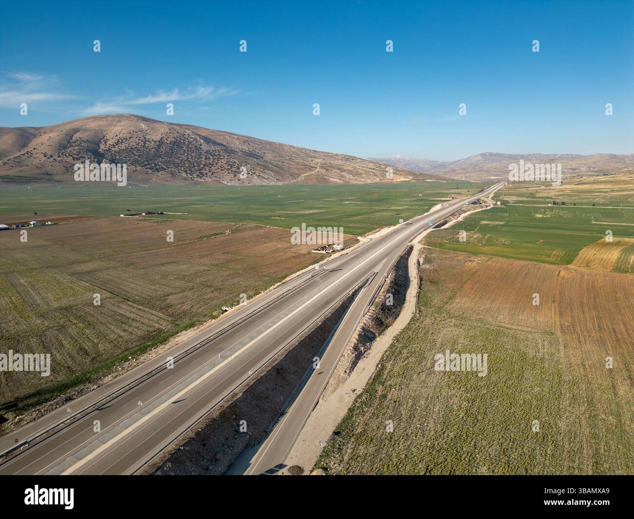Aerial view of a highway cutting through agricultural fields and ...