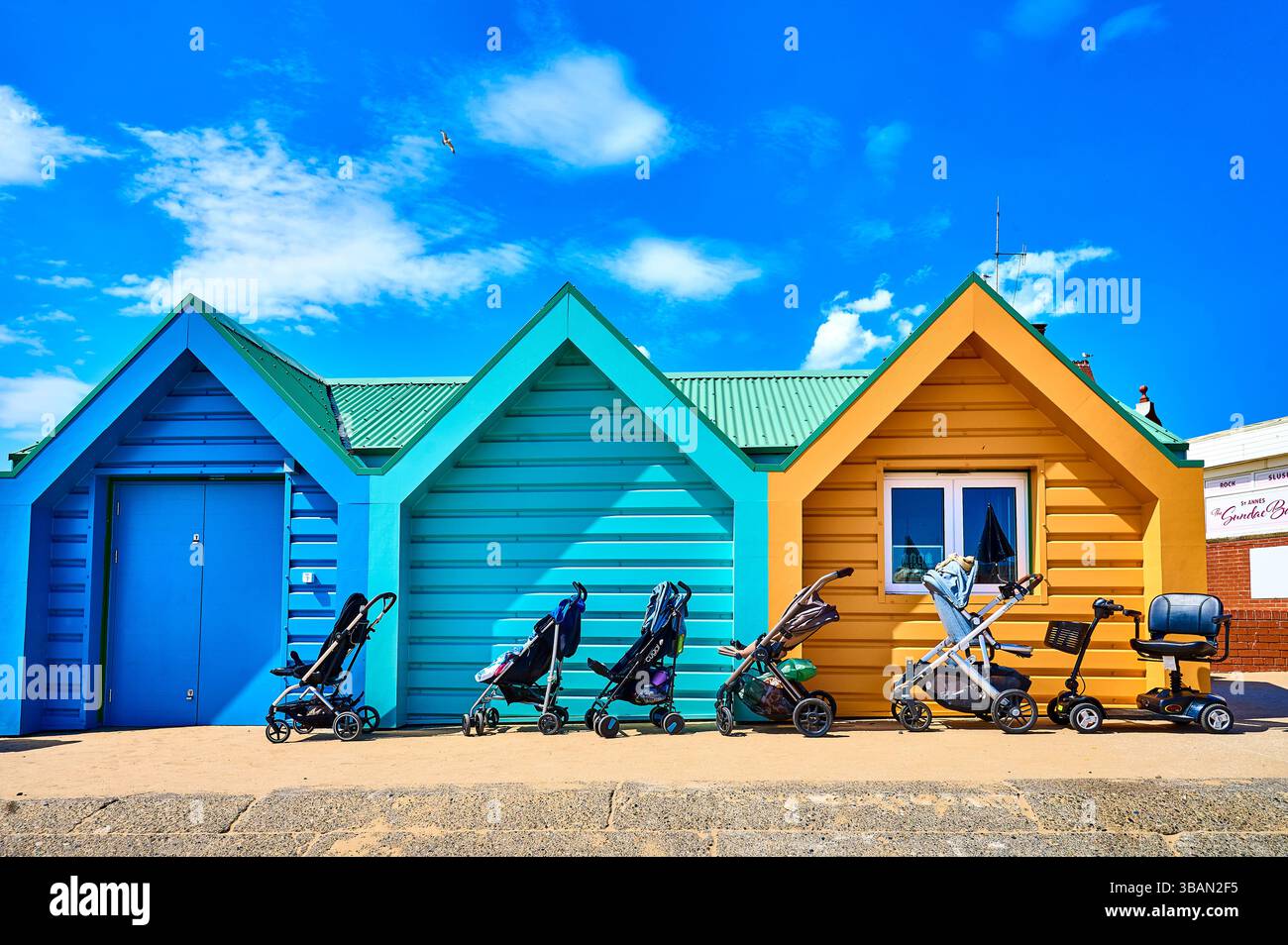 Baby buggies lined up infront of colourful beach huts in St Annes,UK ...