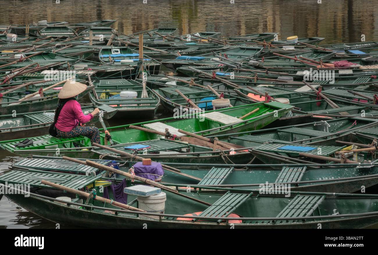 Vietnamese boat driver lady in a traditional hat among multitude of ...