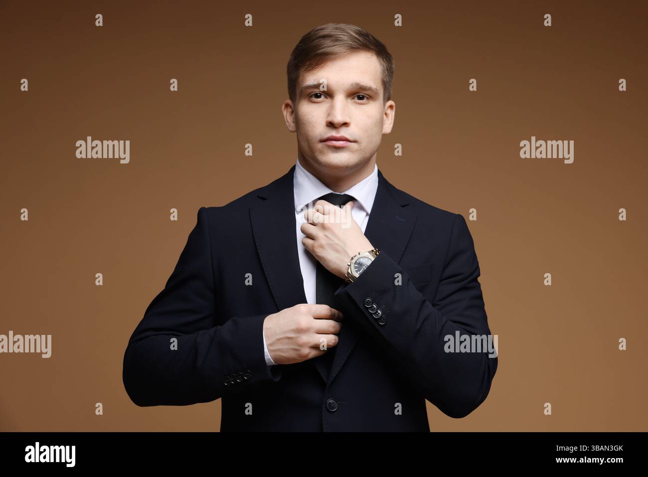 Man in classic suit with stylish watch on brown background Stock Photo ...
