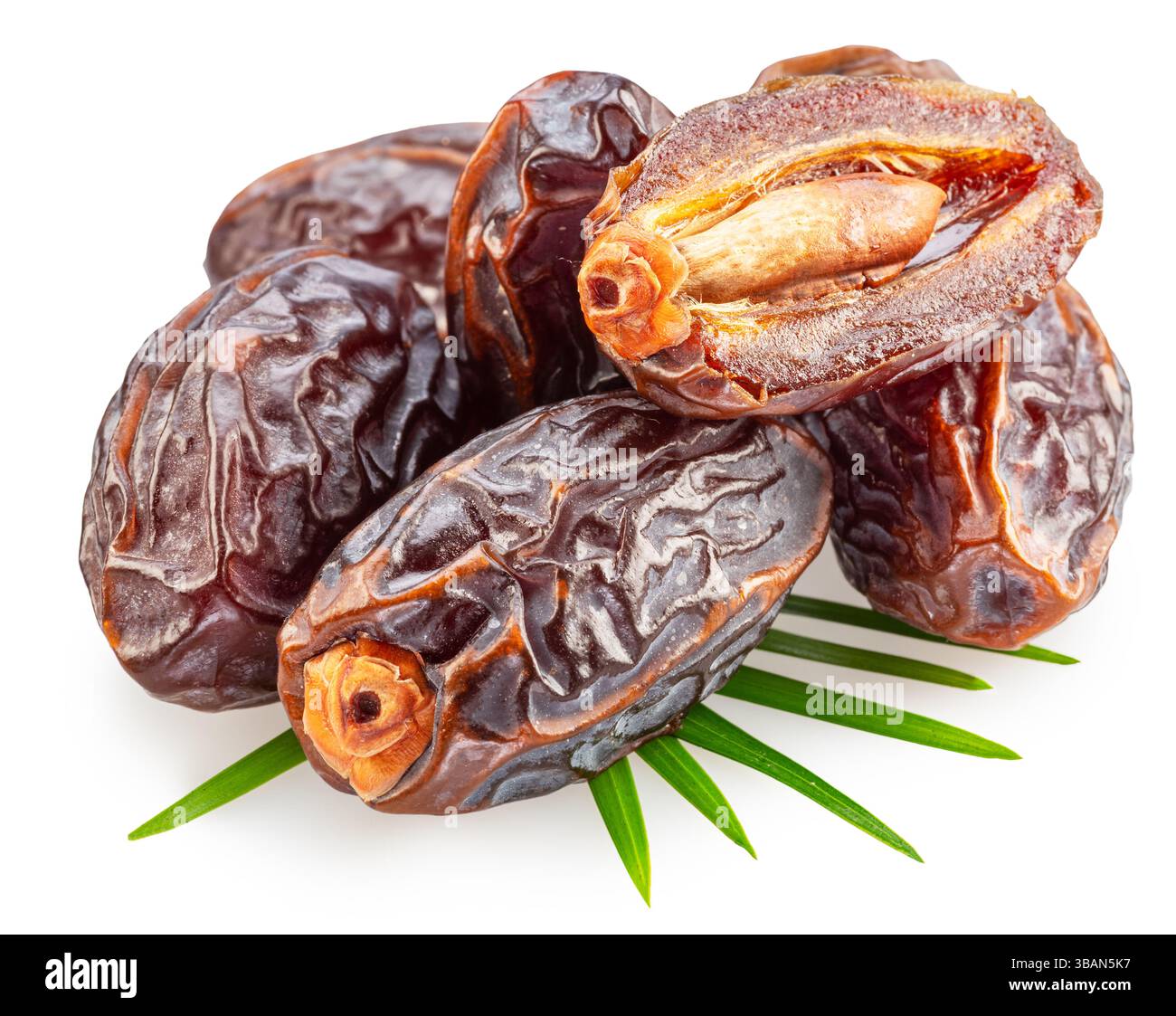 Semi-dried dates and date fruit cut in half lie on palm leaves isolated ...