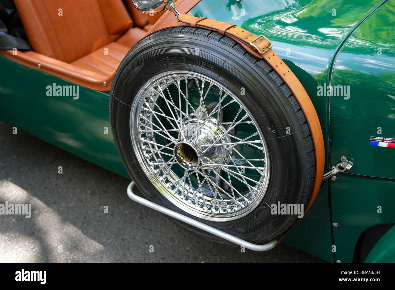 Germany Berlin May 11, 2025. Spare wheel attached to the vehicle with leather strap. A spare ...