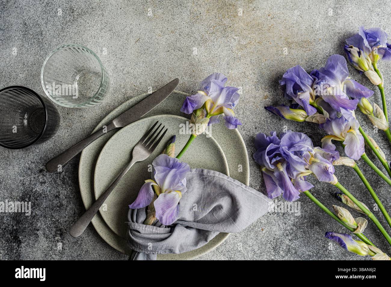 Table setting with pale blue iris flowers Stock Photo - Alamy