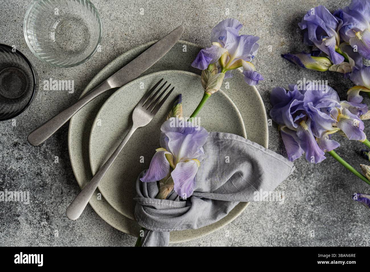 Table setting with pale blue iris flowers Stock Photo - Alamy