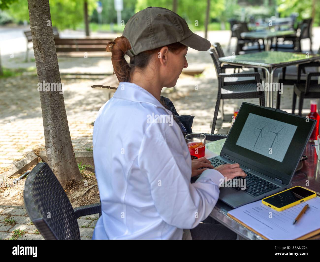 Female engineer designing wind turbines on laptop in outdoor cafe Stock Photo - Alamy