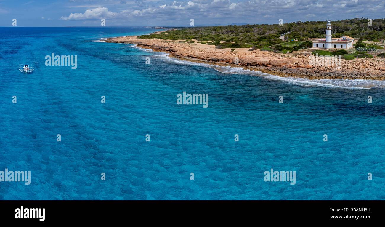 small recreational boat passing in front of the Punta de la Salinas ...