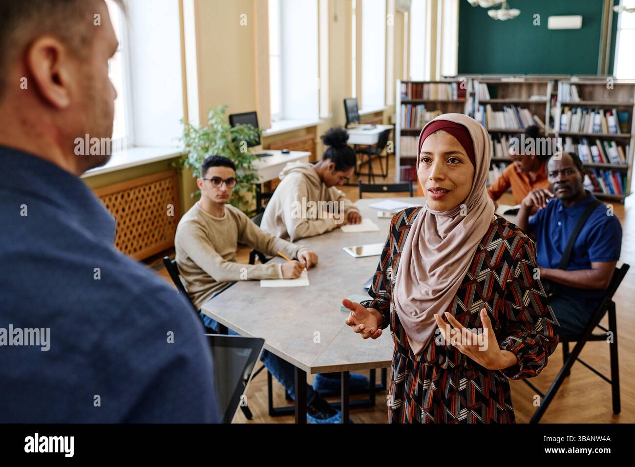 Muslim woman wearing hijab standing in front of English language ...
