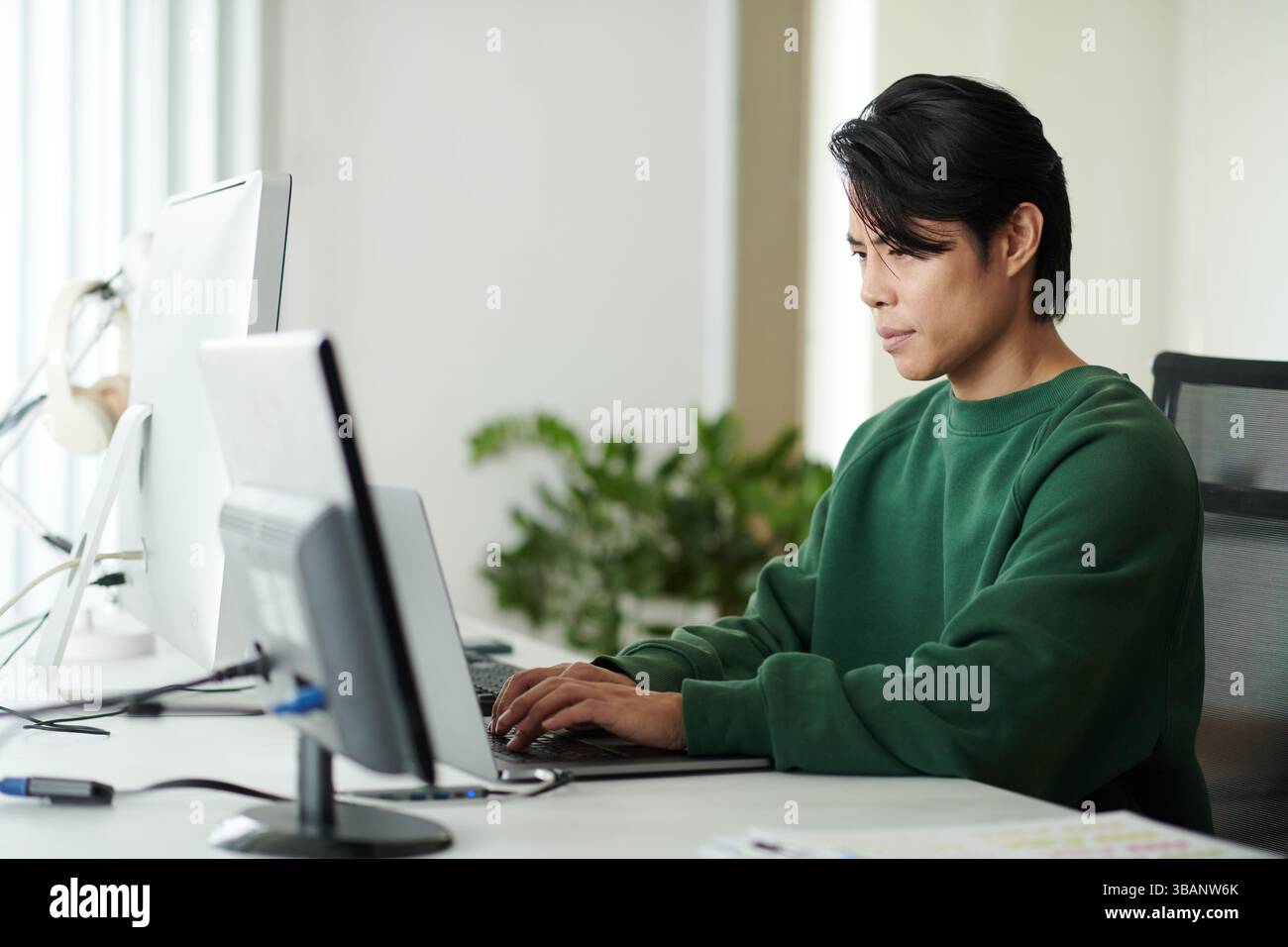 Portrait of serious Asian man coding on laptop at his office desk Stock ...