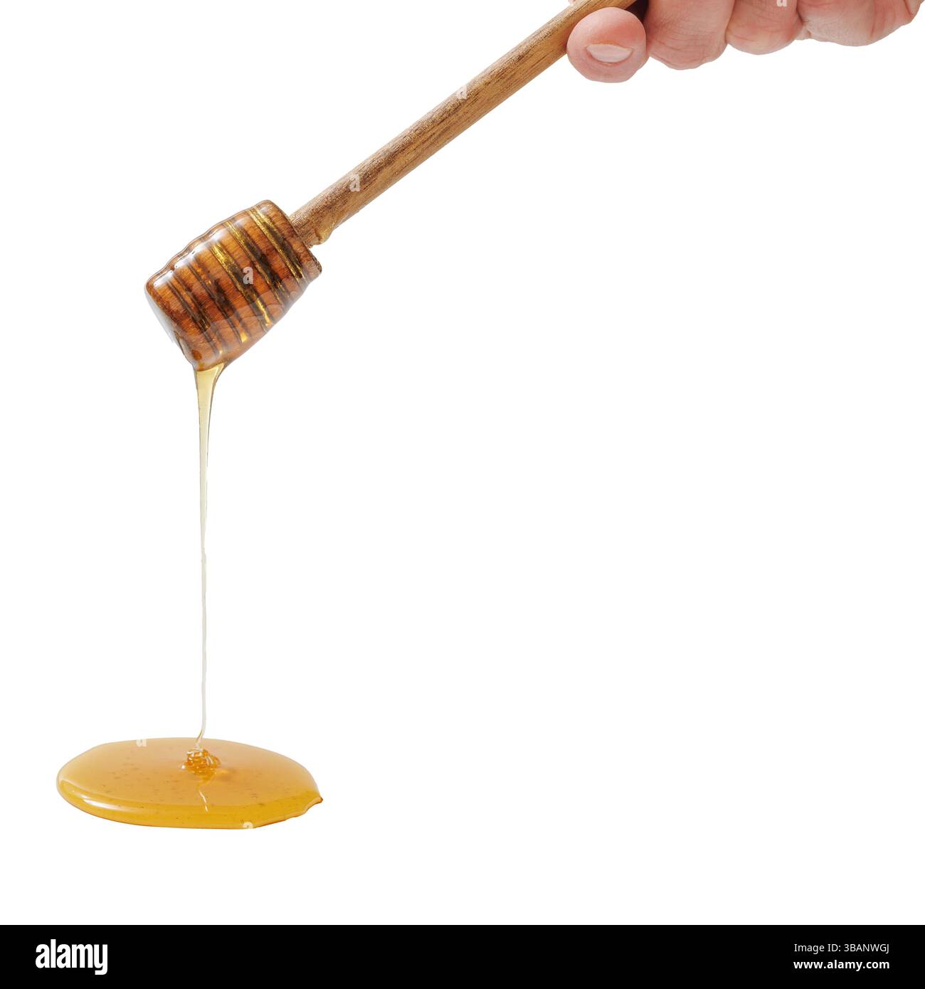 Close-up of a hand holding a handcrafted wooden spoon with golden honey ...