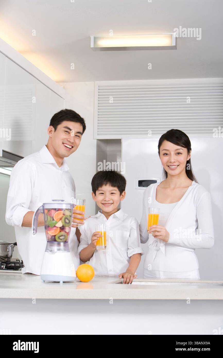 Chinese family drinking fresh orange juice in kitchen Stock Photo - Alamy