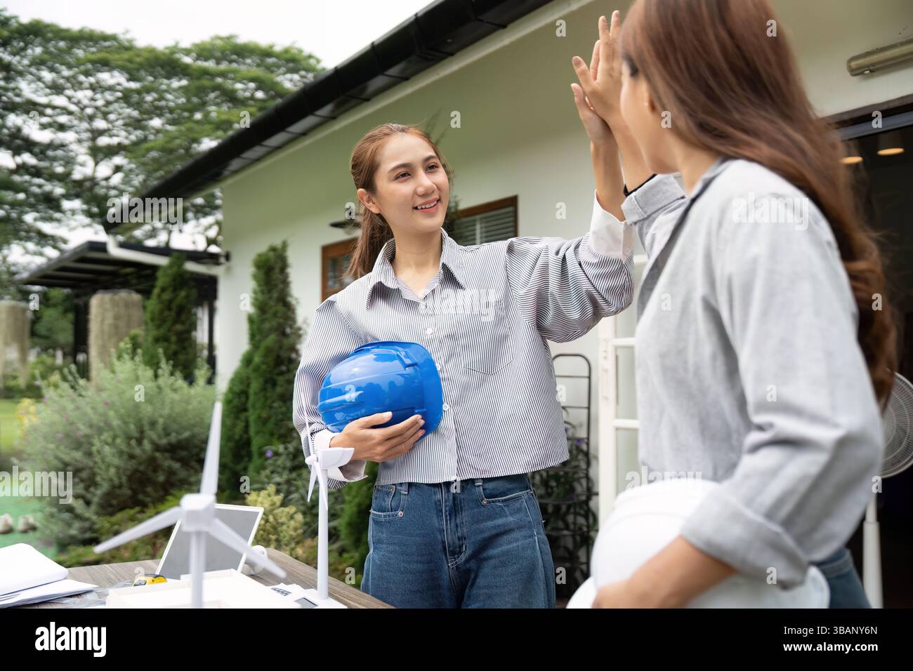 Sustainability engineer collaborating outdoors with blueprints and ...