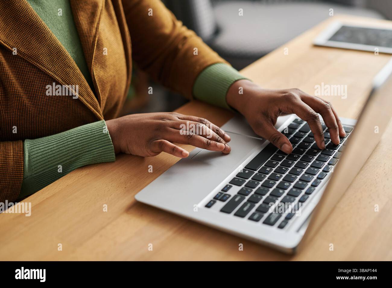 Hands of self employed black woman in smart casualwear typing on laptop ...