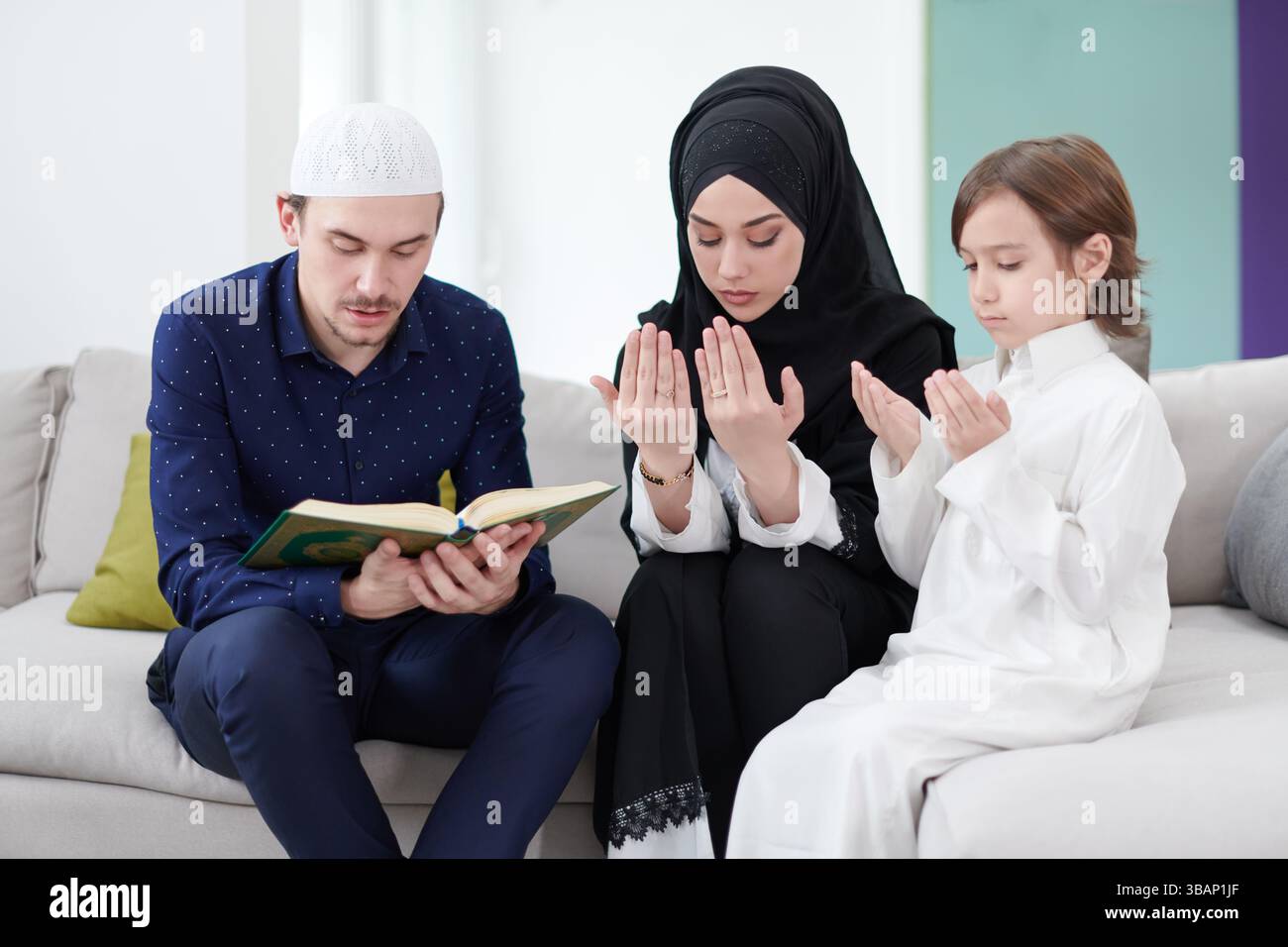 Traditional muslim family parents with children reading Quran and ...