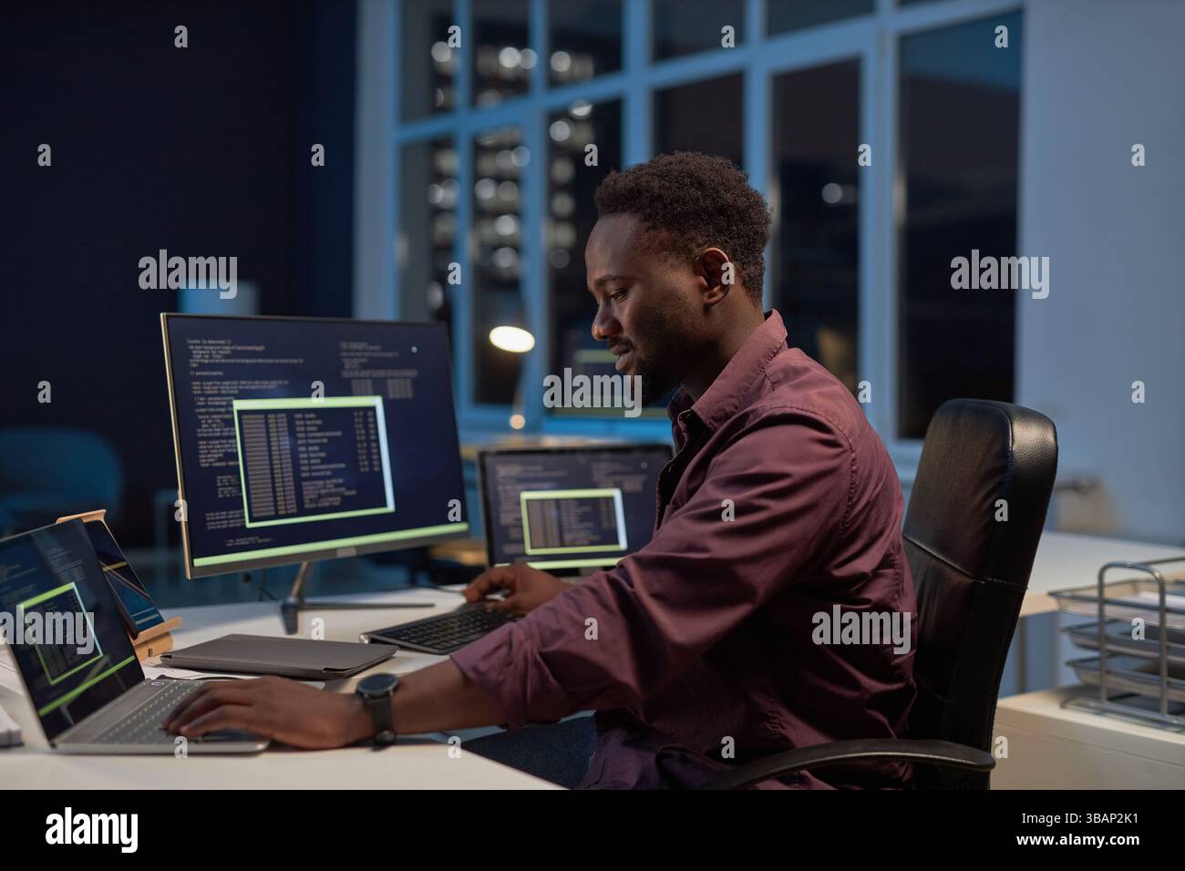 African American developer developing software on computer using codes while working in office ...