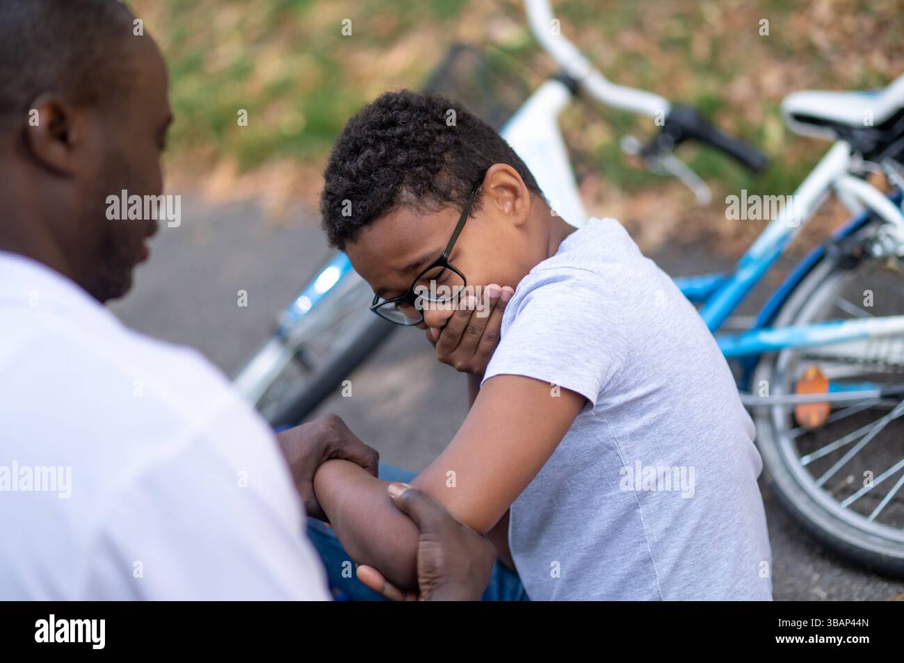 Falling down. Dad helping his son after falling down from a bike Stock ...