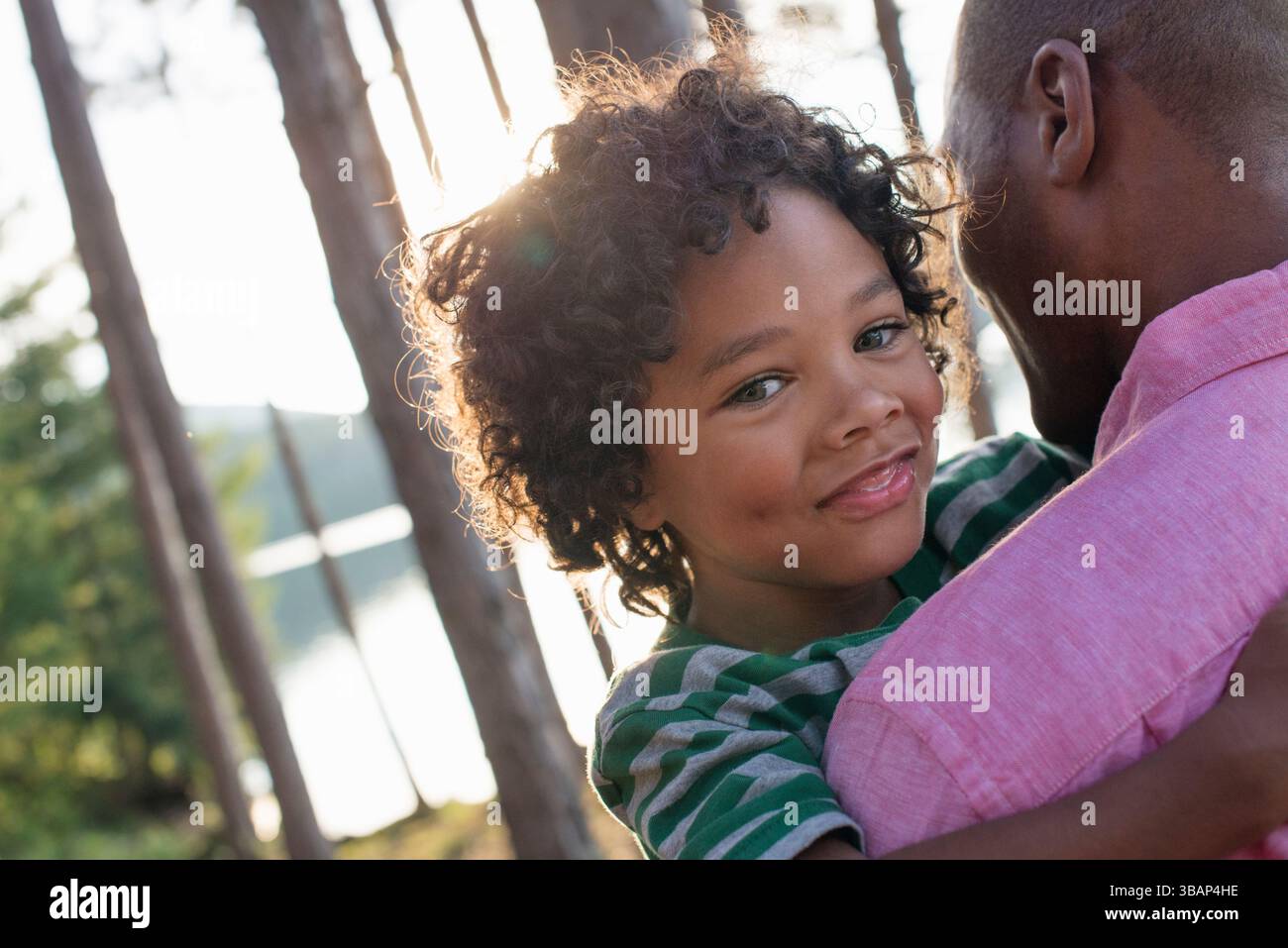 Trees on the shores of a lake. A man carrying a child in his arms Stock ...