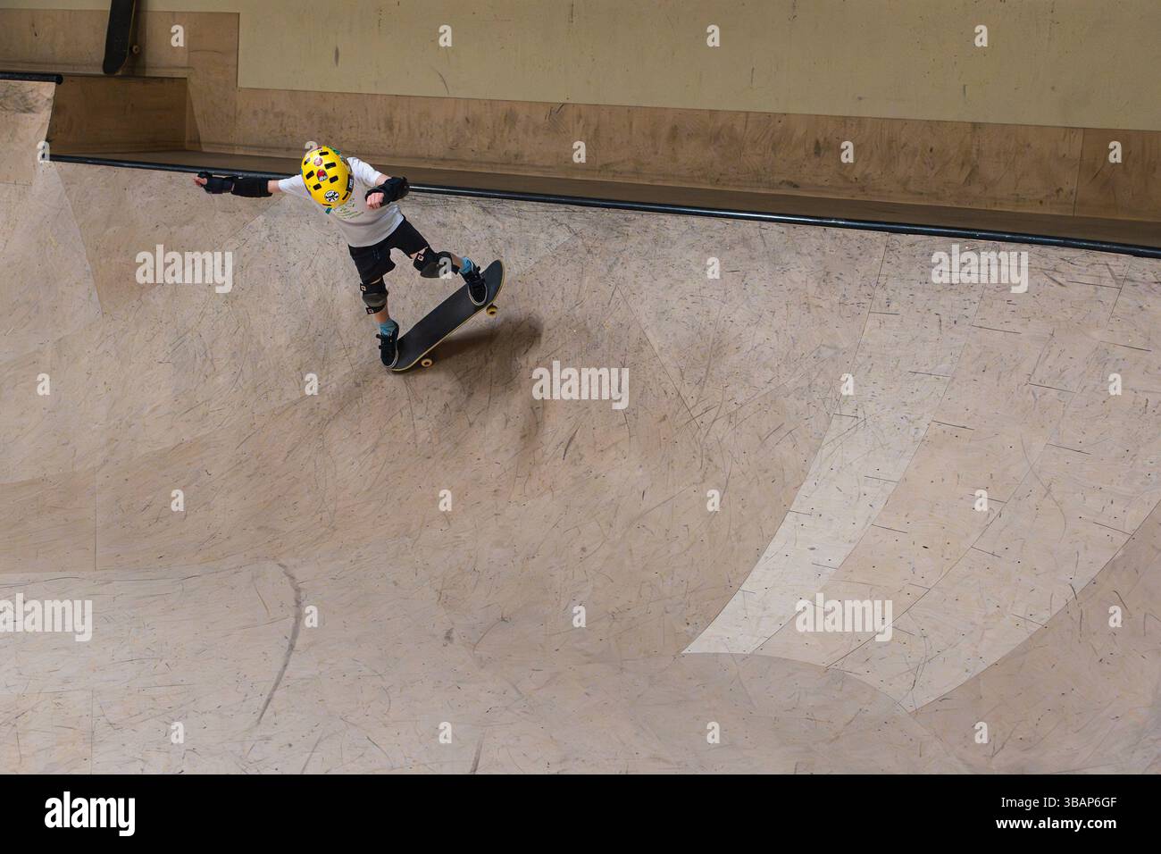 Child skateboarding in a skate park, performing a trick Stock Photo - Alamy