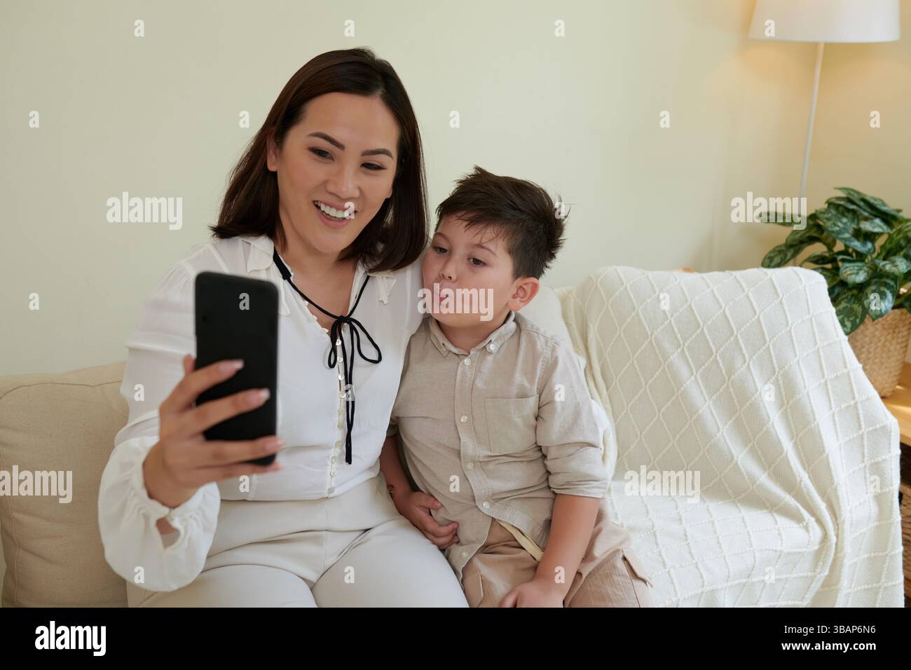 Little boy making duck face when taking selfie with his mother Stock ...