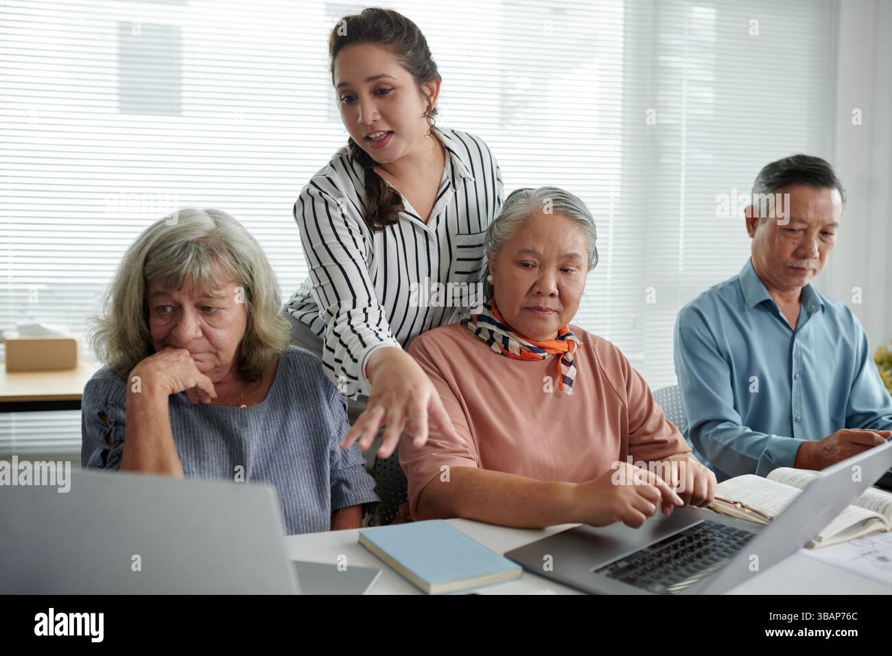 Teacher explaining confused seniors how to use web browser Stock Photo ...