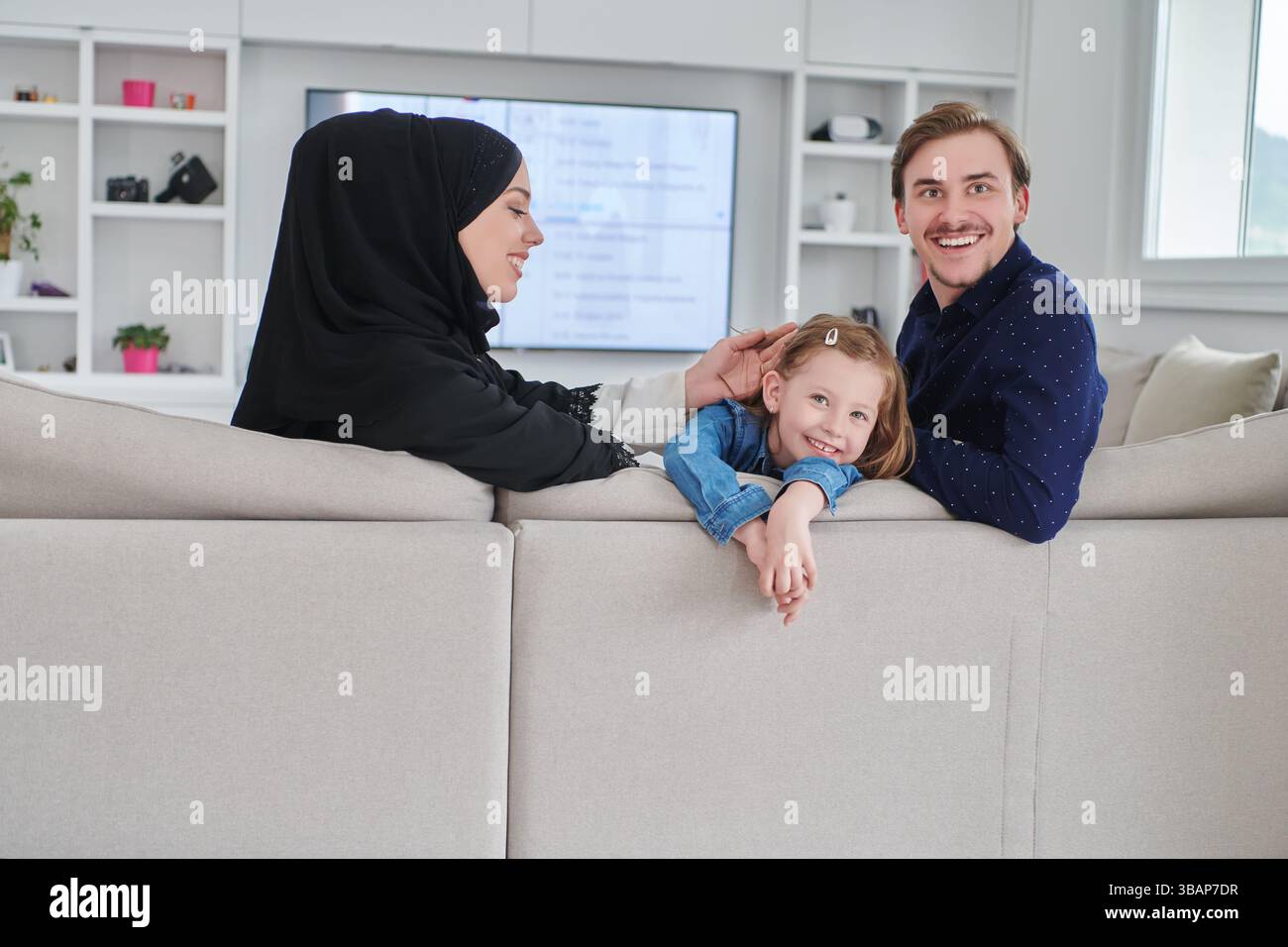Happy Muslim family spending time together in modern home. Parents ...