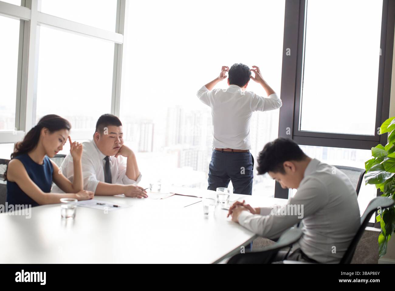Angry Chinese male boss standing and facing window while scolding his ...