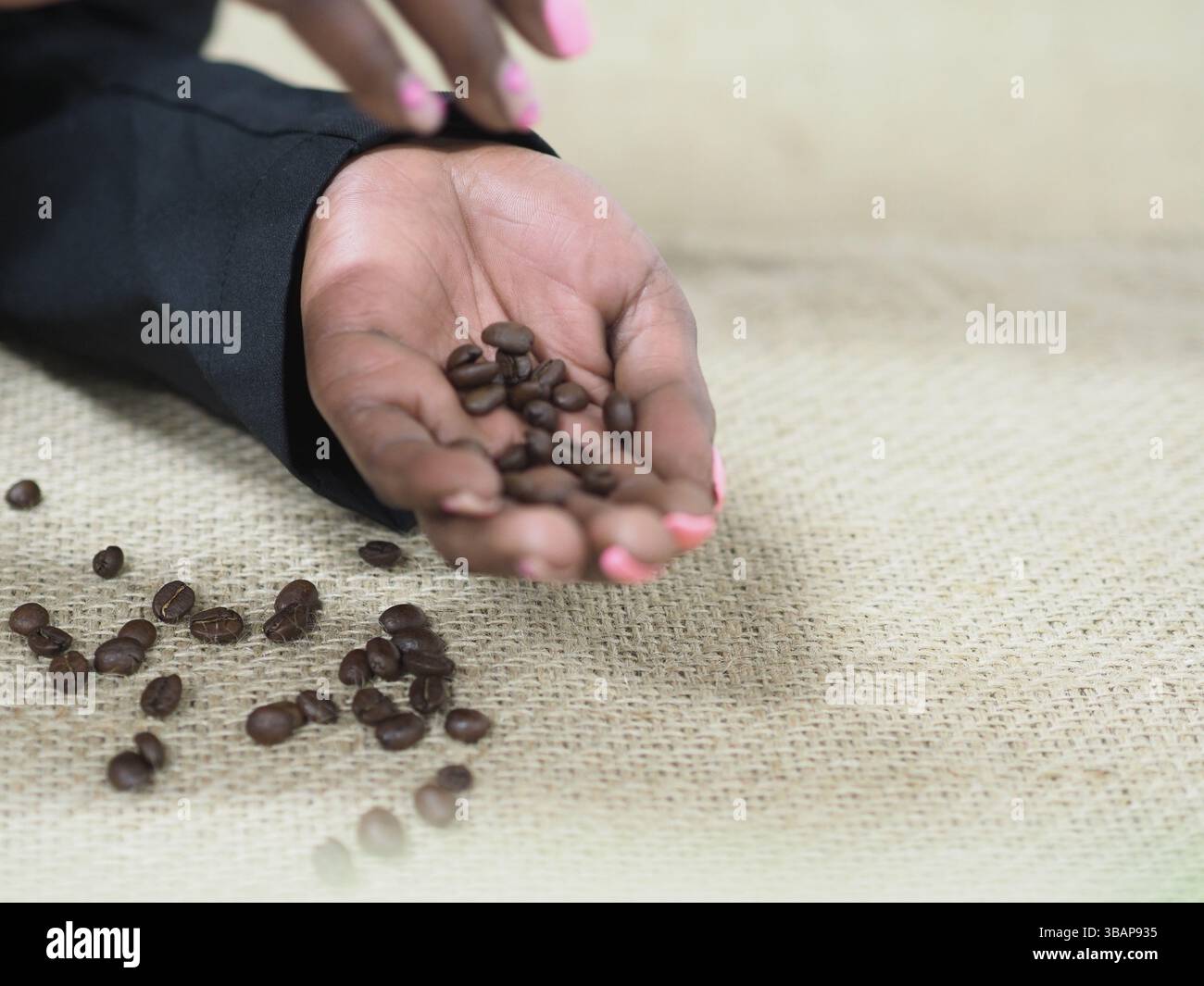 Black female hand with coffee beans Stock Photo - Alamy