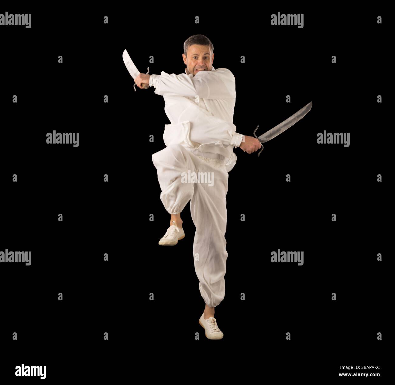 Man wearing all white with two swords Stock Photo - Alamy
