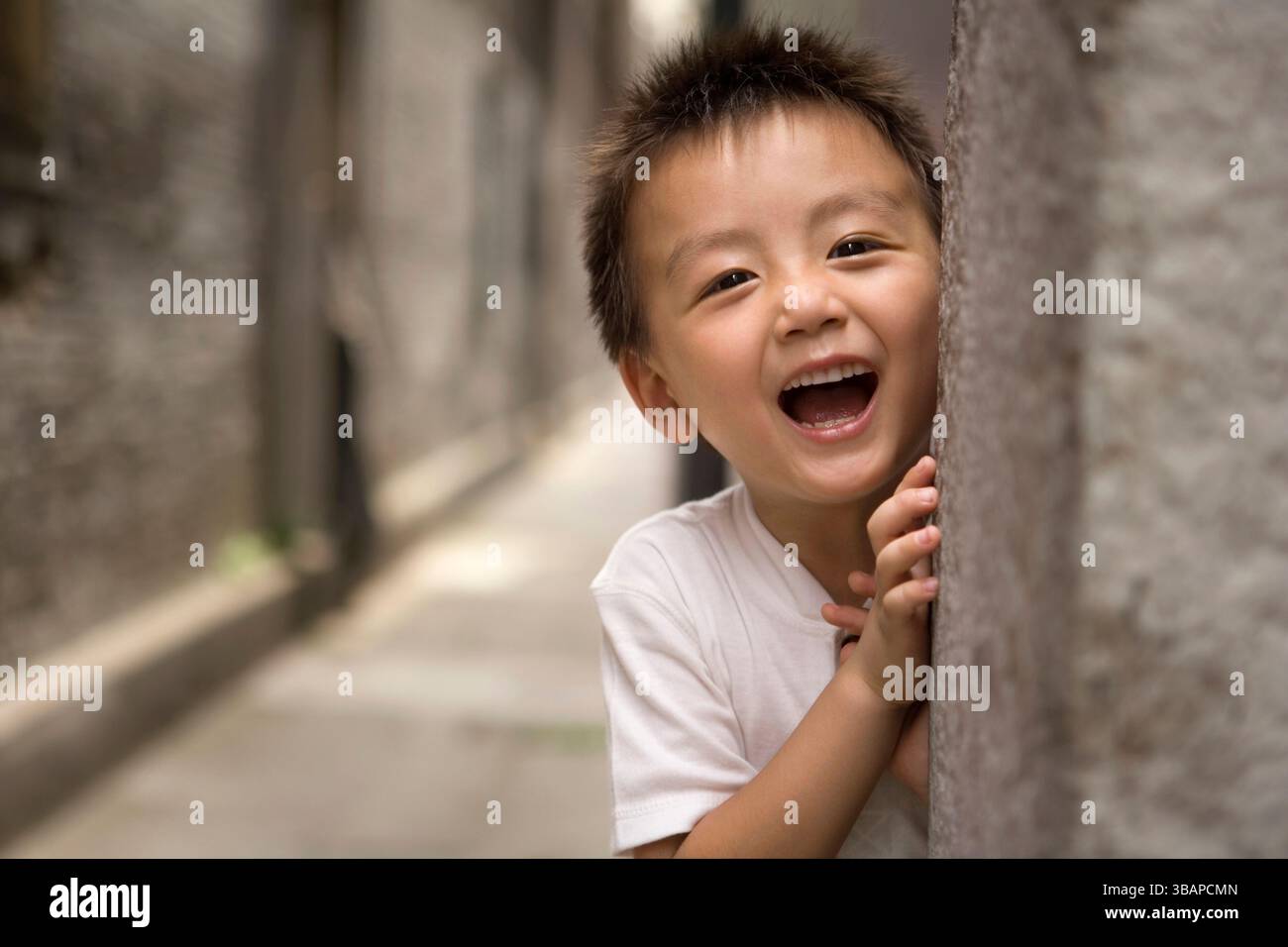 Chinese boy playing hide and seek Stock Photo - Alamy