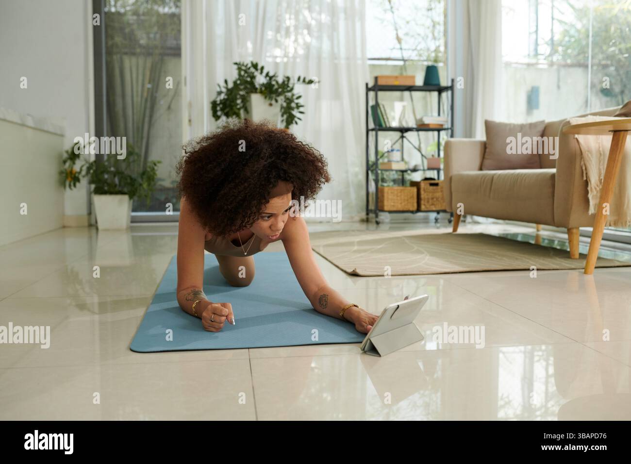 Woman following tutorial on tablet computer when learning how to do ...