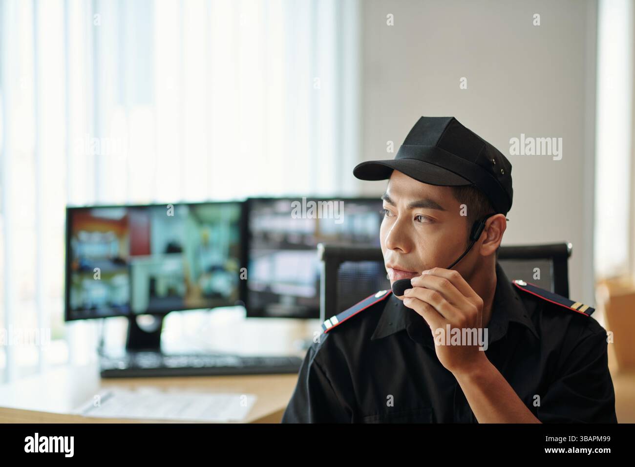 Portrait of security guard in black uniform communicating with coworker ...