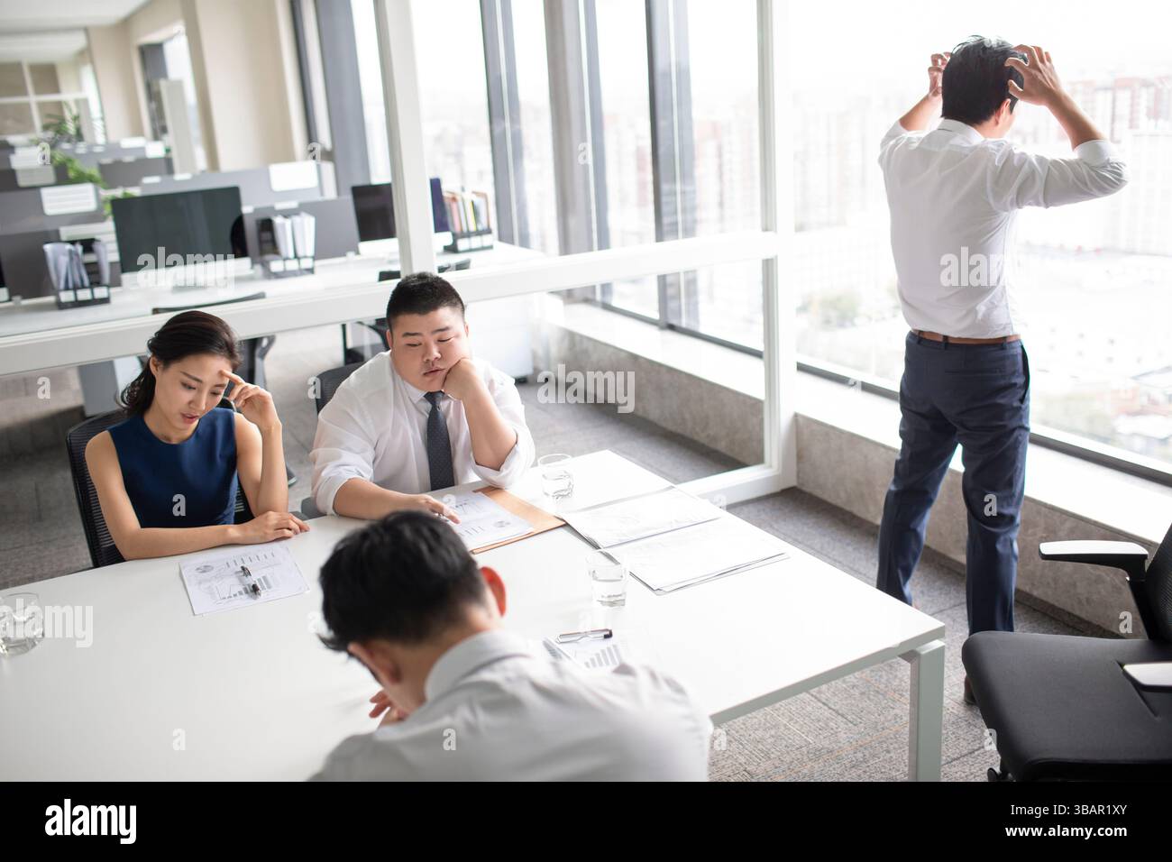 Angry Chinese male boss standing and facing window while scolding his ...