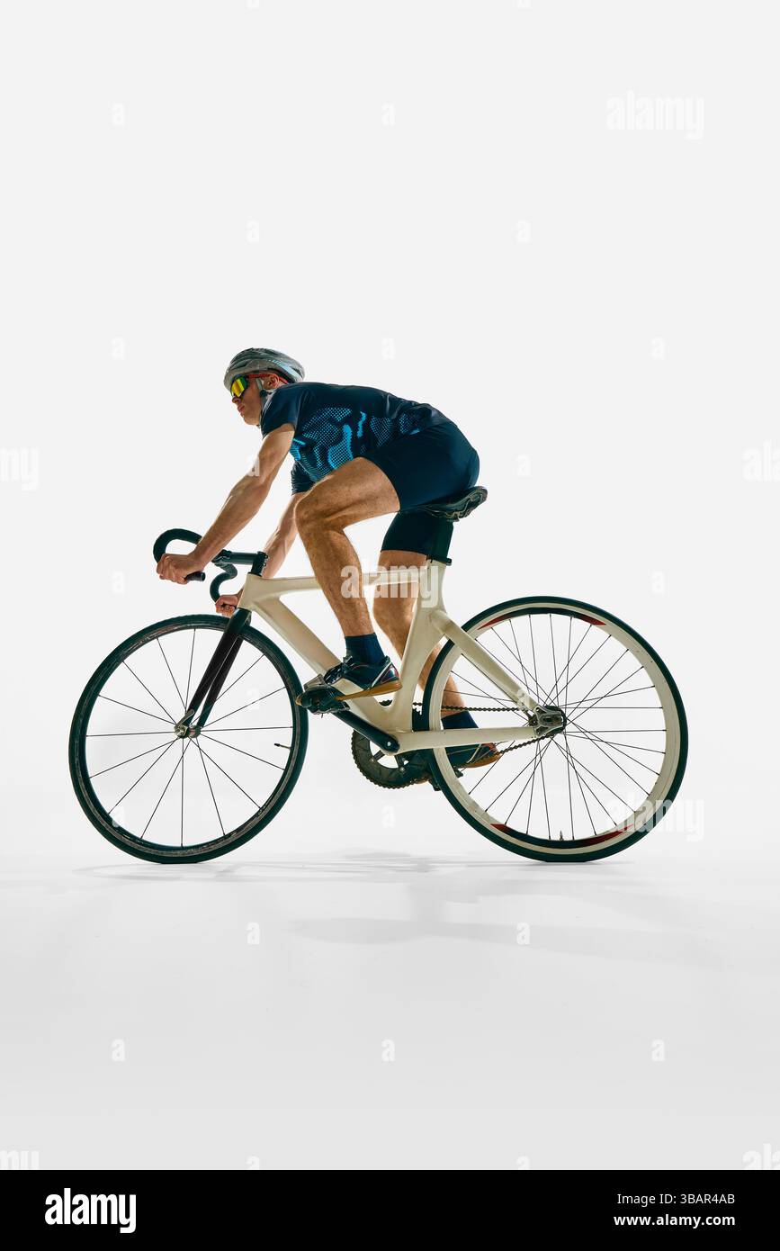 Side view low angle image of man, professional cyclist in full gear ...