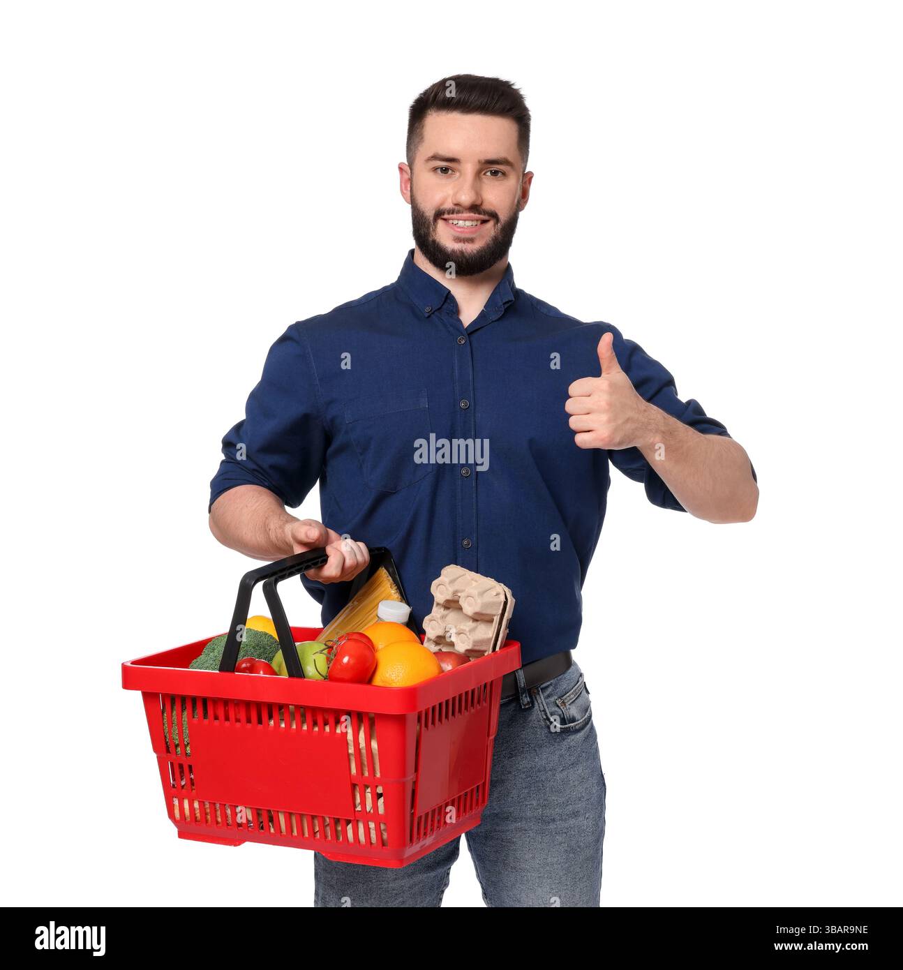 Man with shopping basket full of products showing thumbs up on white ...